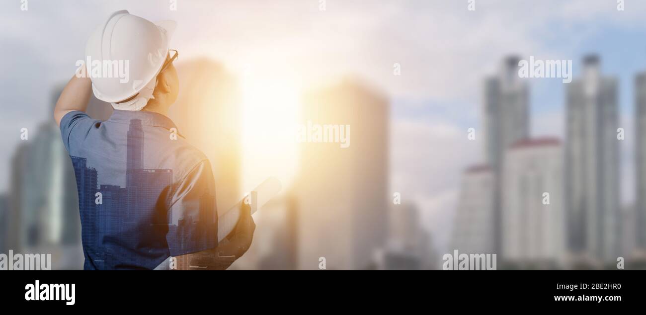 engineer holding blueprint with construction building background ...