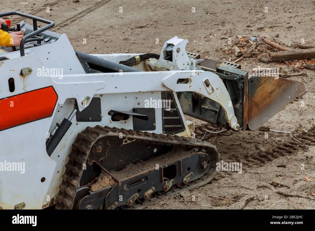 Mini bulldozer with earth doing landscaping works level the ground ...