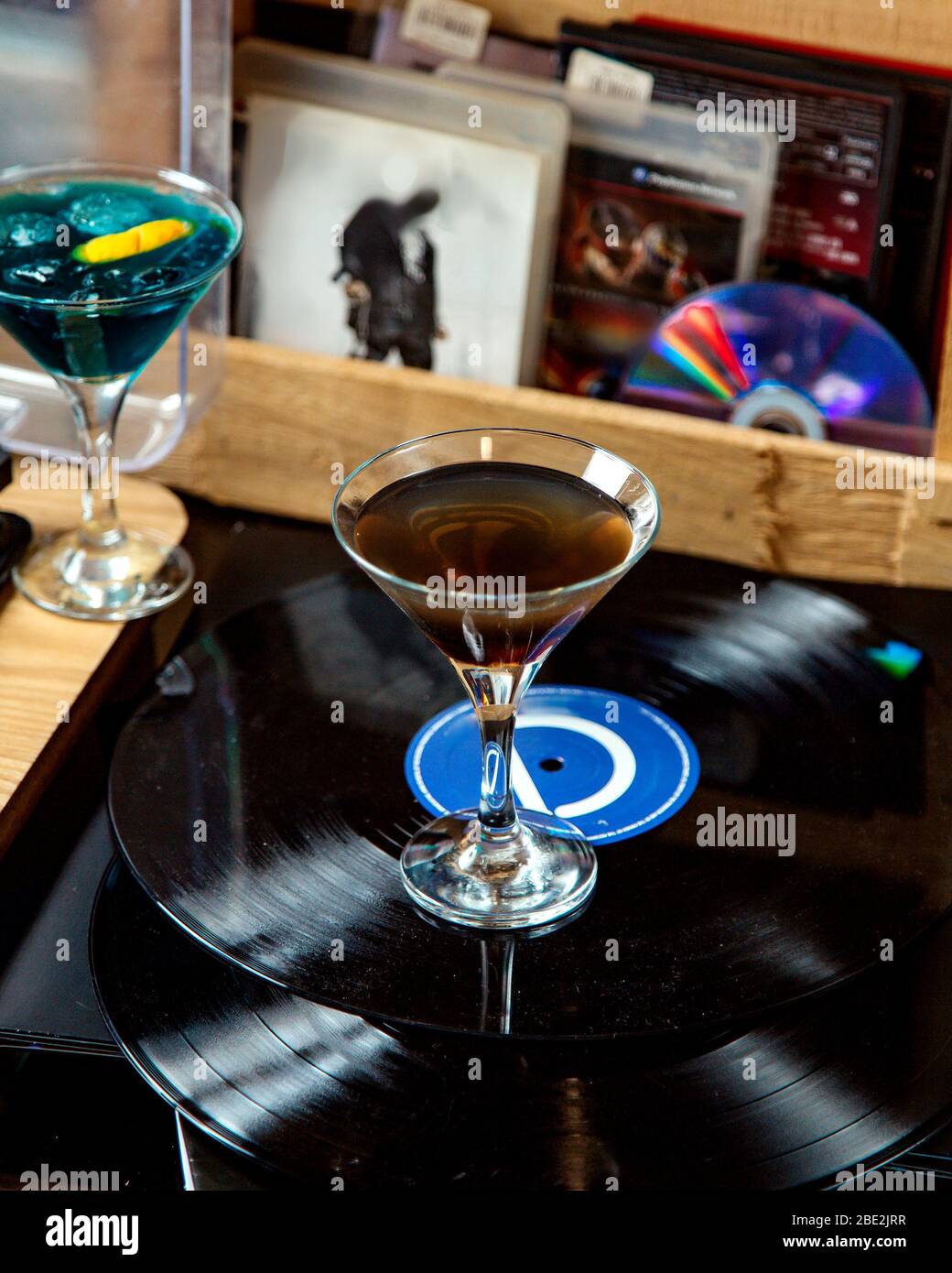 a martini glass with dark colored cocktail placed on vinyl record Stock ...