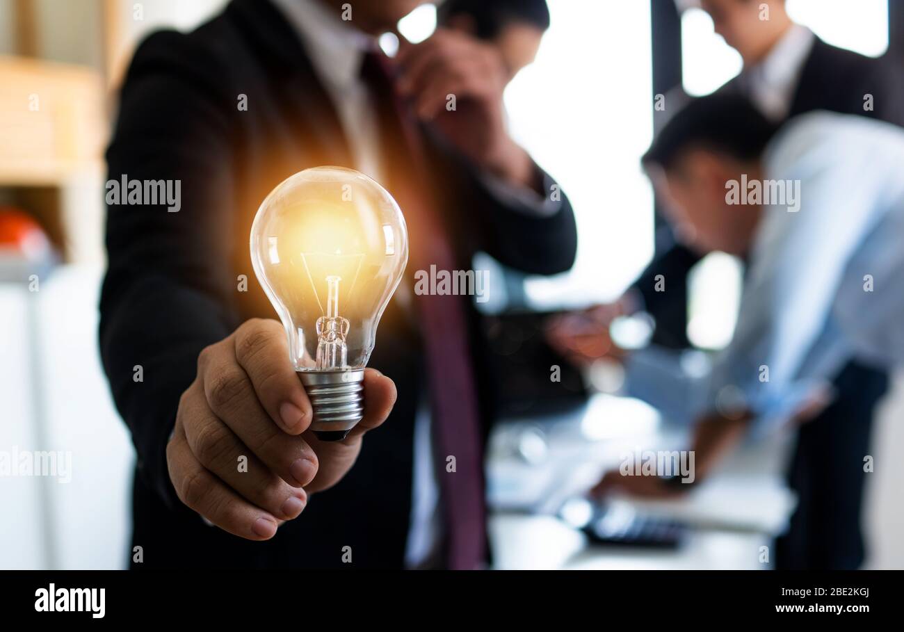 Innovation and idea of professional leader holding lighting bulb ...