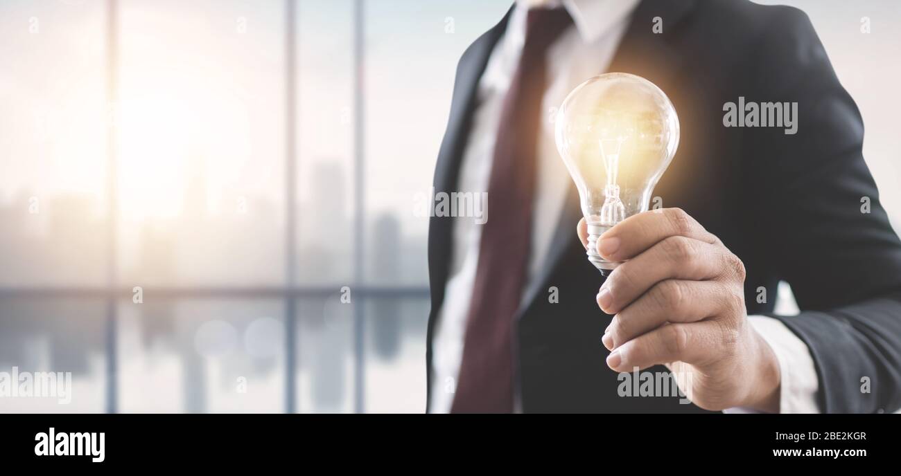 Innovation and idea of professional leader holding lighting bulb ...