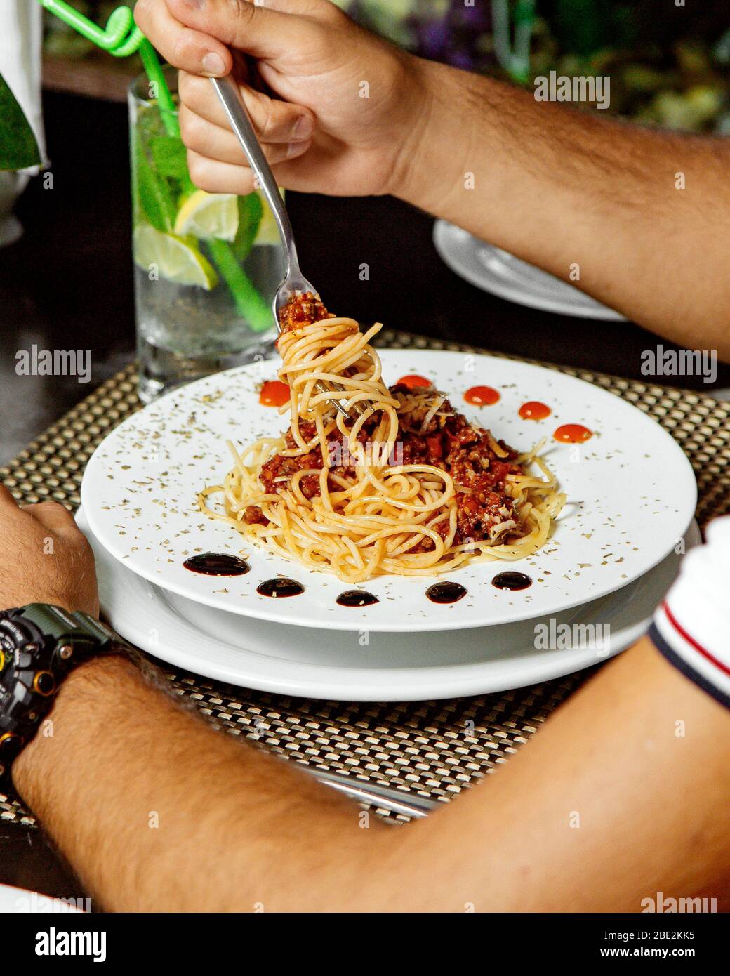 man eating spaghetti bolognese garnished with dried mint leaves Stock ...