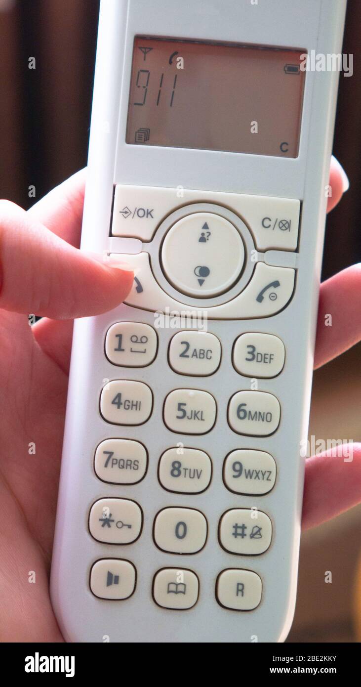 Cordless phone in hand. Emergency number 911 Stock Photo - Alamy