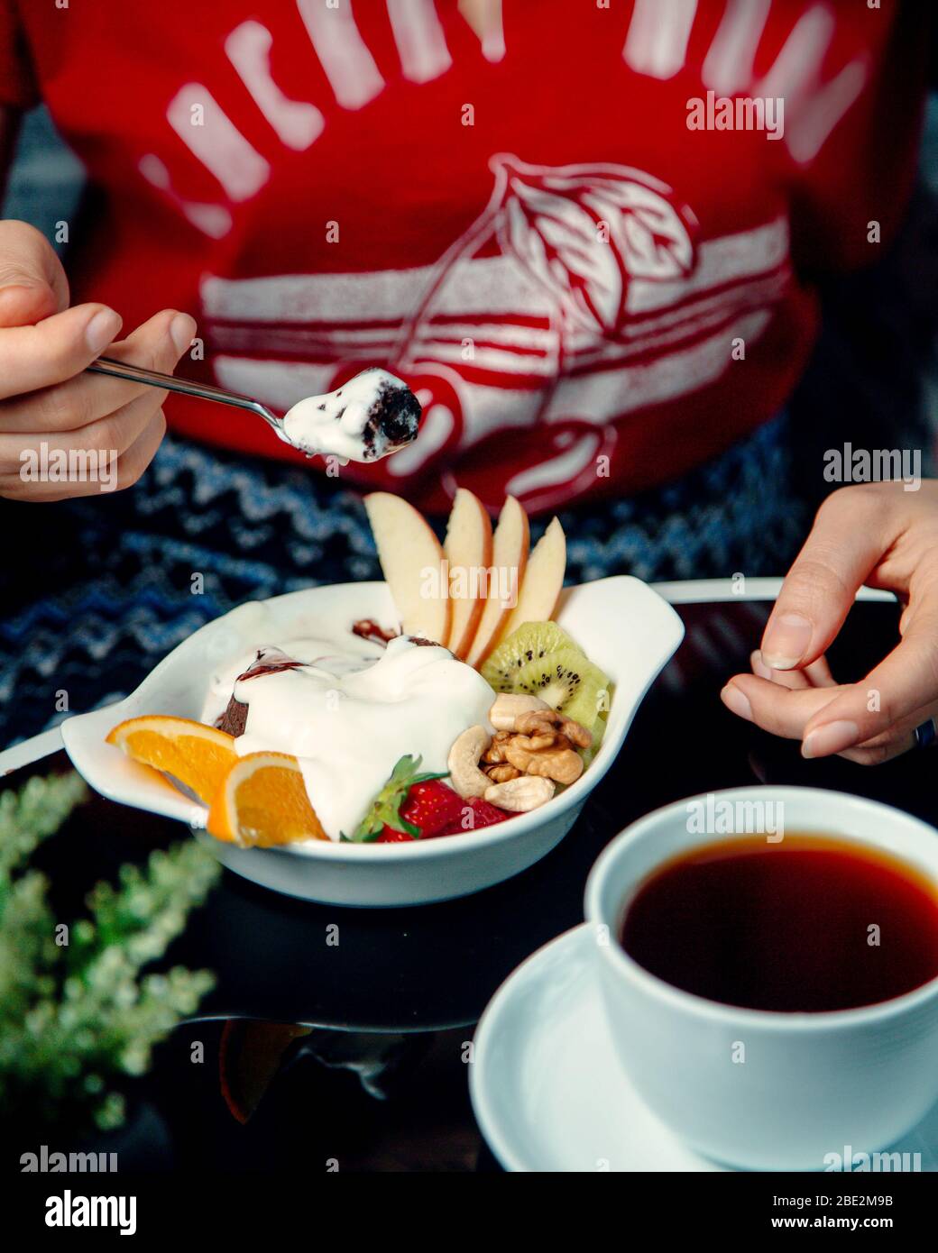 woman eating chocolate volcano and ice cream mix served with fruit ...