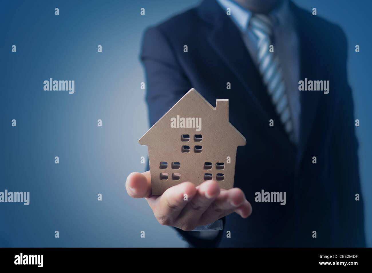 Businessman, agency banker holding house model and present real estate ...