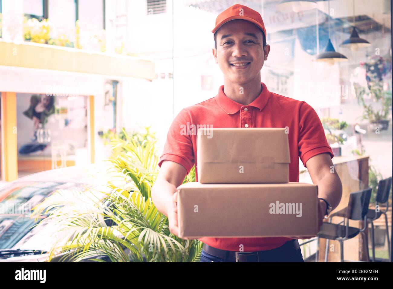 Postman holding parcel with fast delivery to customer Stock Photo - Alamy