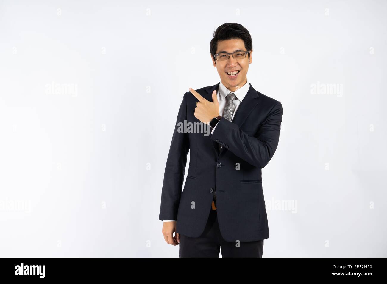 Smart Asian businessman in suit pointing up for presentation on copy ...