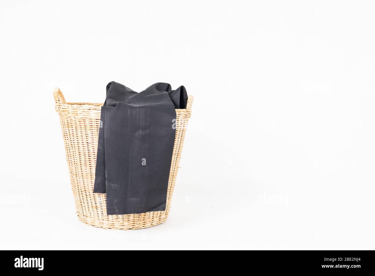 Wicker basket of clothes isolated on white background Stock Photo - Alamy