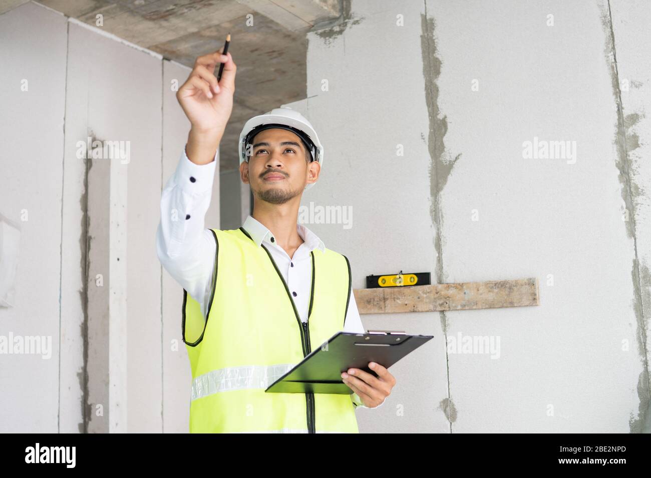 Inspector holding clipboard opening paper and checking building for ...