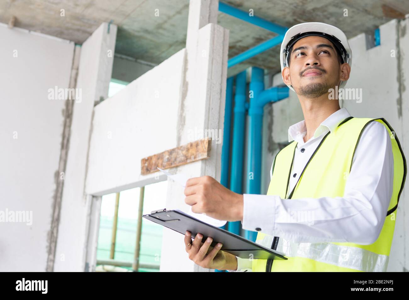 Inspector holding clipboard opening paper and checking building for ...