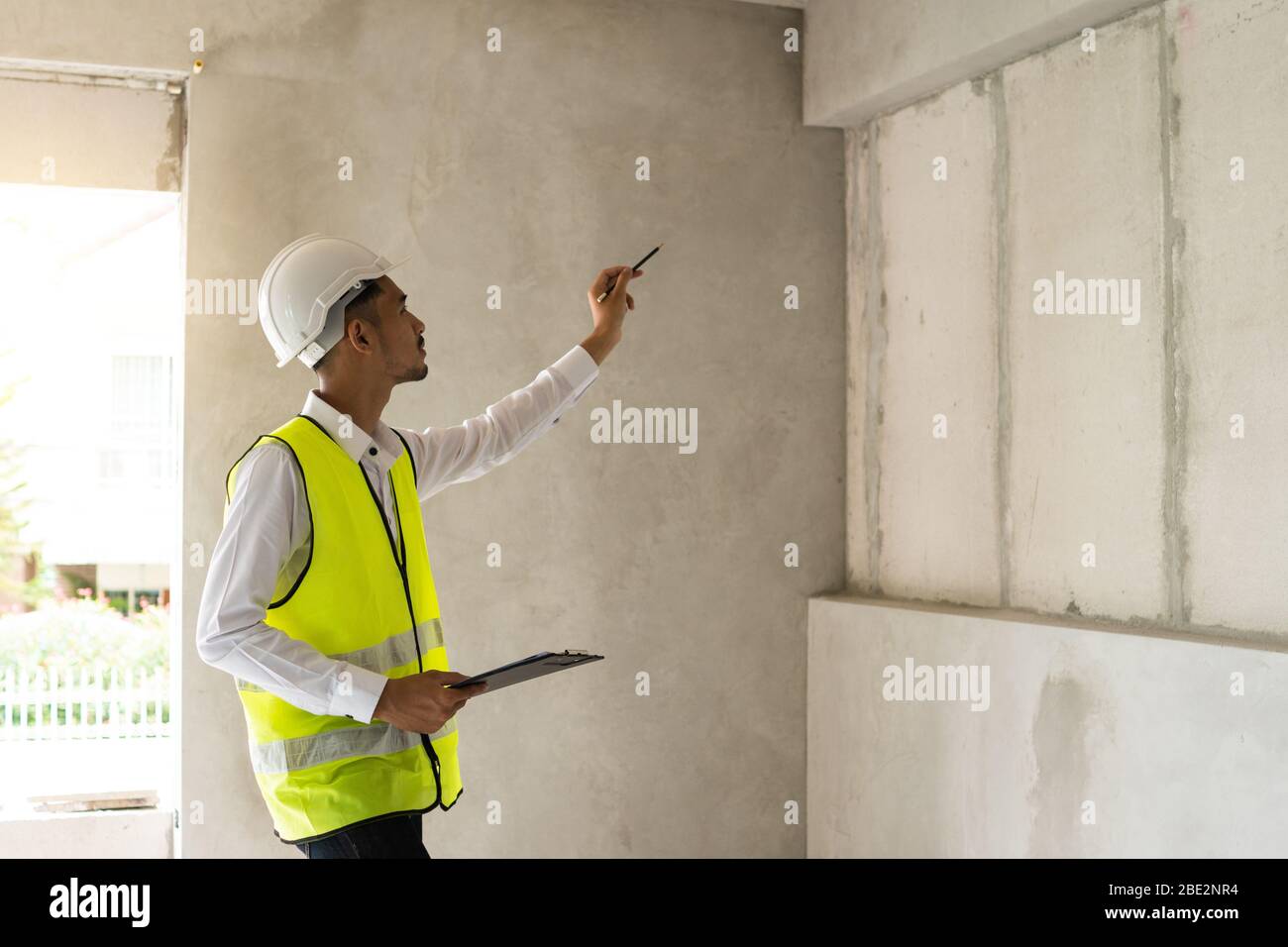 Inspector holding clipboard opening paper and checking building for ...