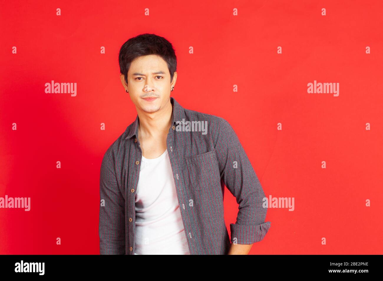 A portrait of a young hipster man making a curious face while shooting ...