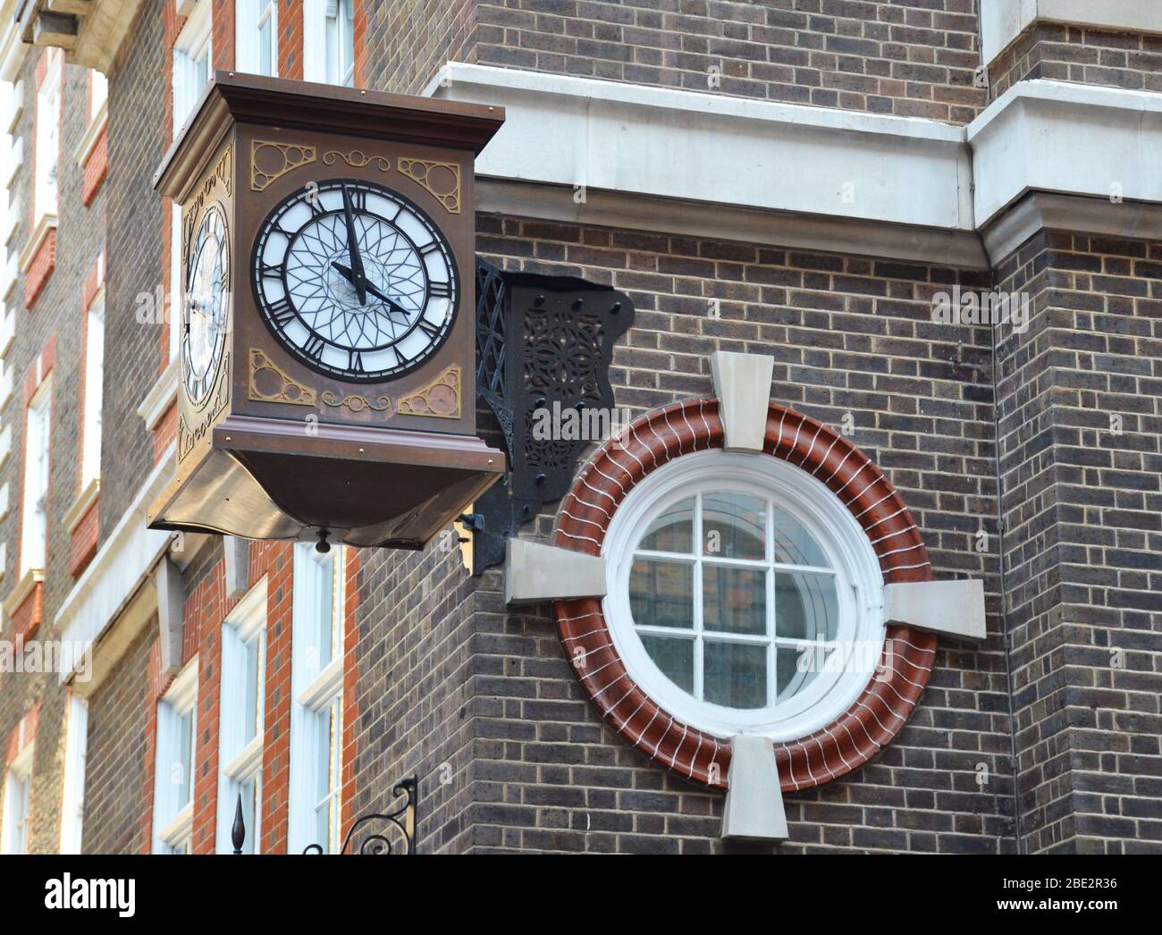 Small clock on a building wall Stock Photo - Alamy