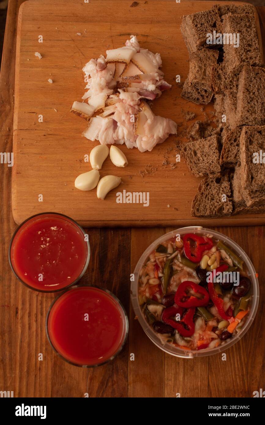 Traditional Russian snack. Salo bread pickles. Two glasses of tomato ...