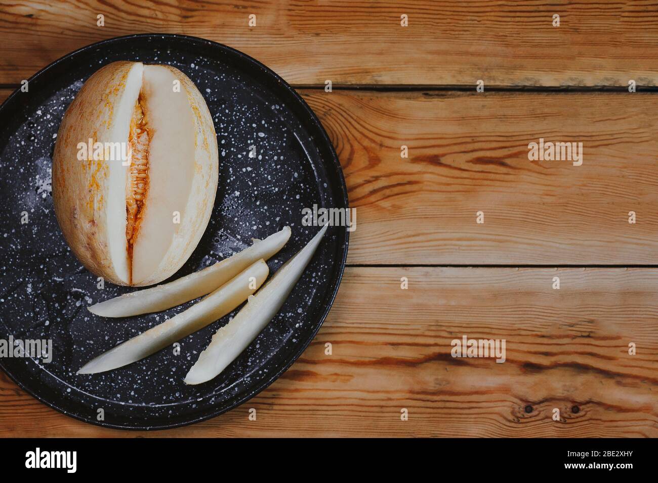 Slices of sweet organic summer melons on the dark wooden background ...