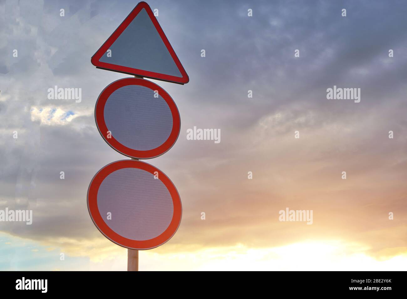 Warning road sign against a cloudy sky with clouds Stock Photo - Alamy