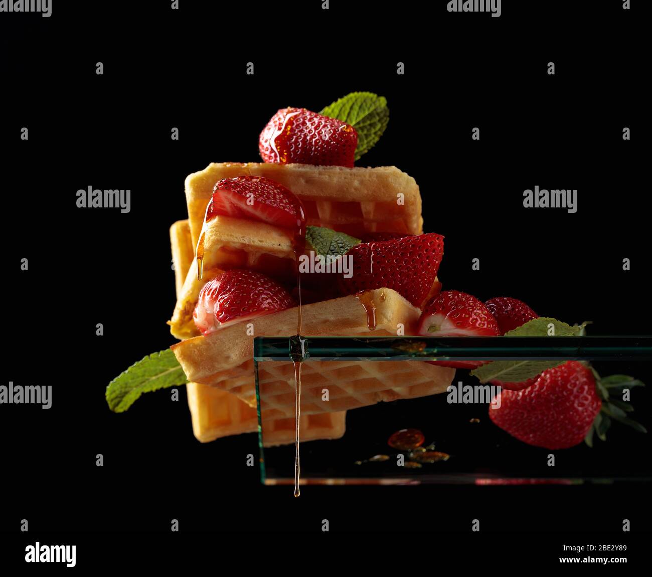 Waffles with strawberries and honey garnished with fresh mint Stock ...