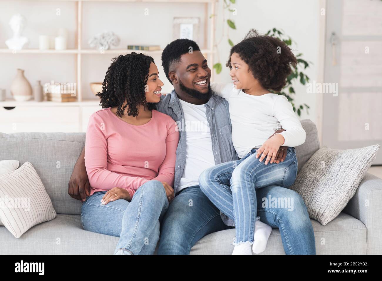 Happy African American Parents Bonding With Their Little Daughter At ...
