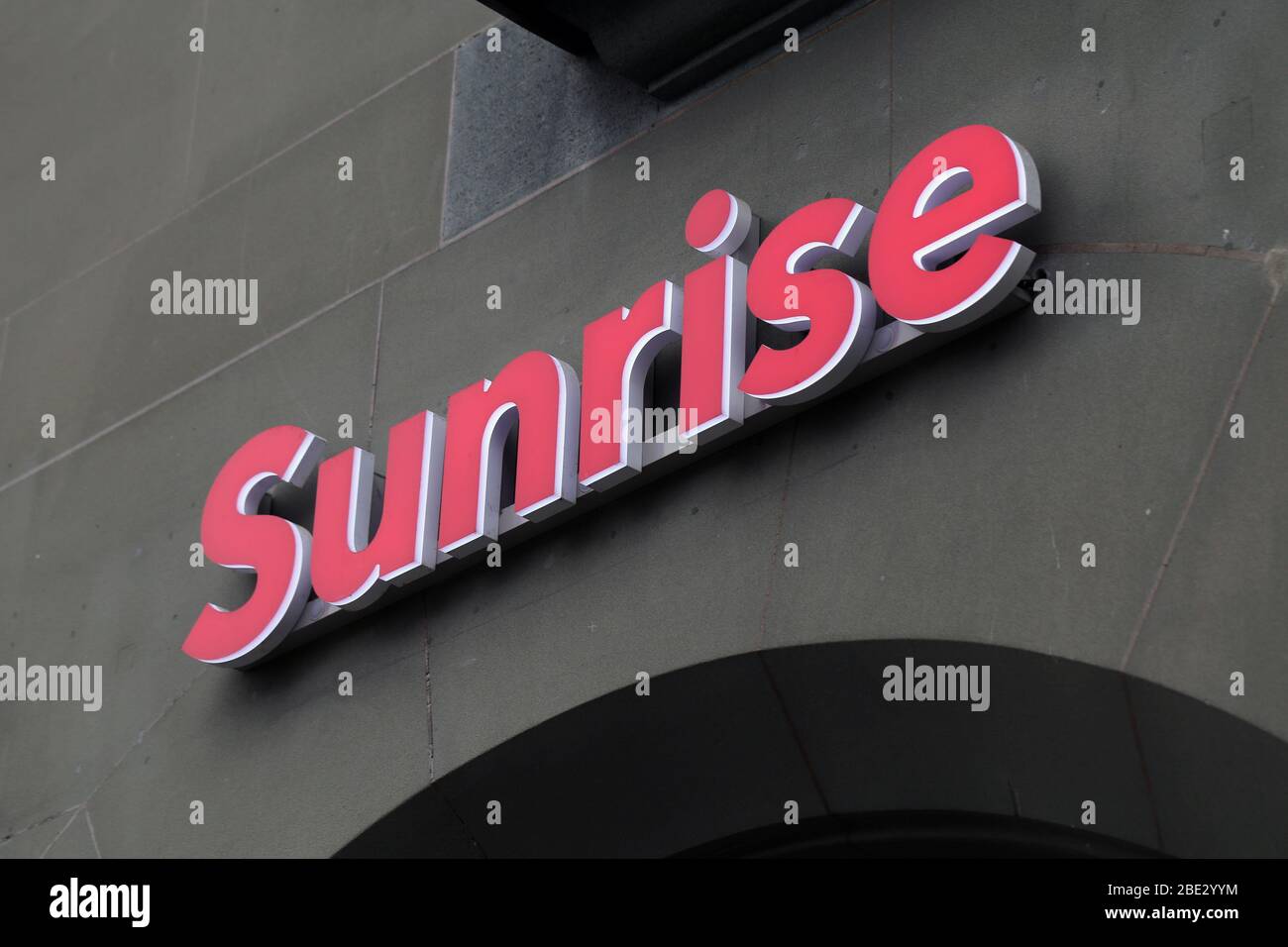 Light up red logo sign of Sunrise on a wall of an old building located ...