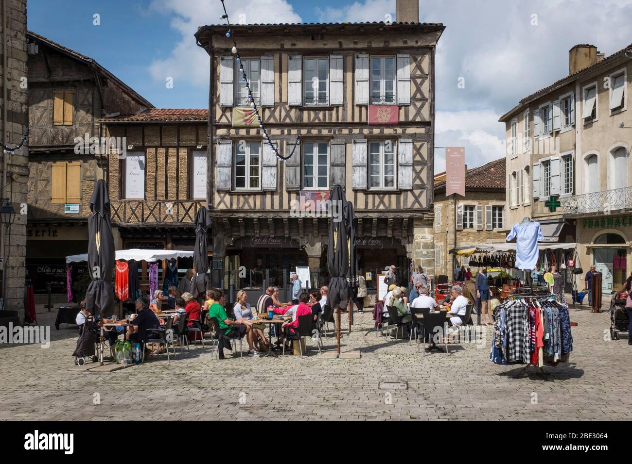 Tourists seated at outdoor cafe tables enjoy the historic centre of ...