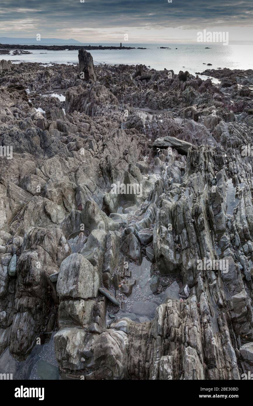 Weathered rock formations and rock pools at low tide at Portwrinkle ...