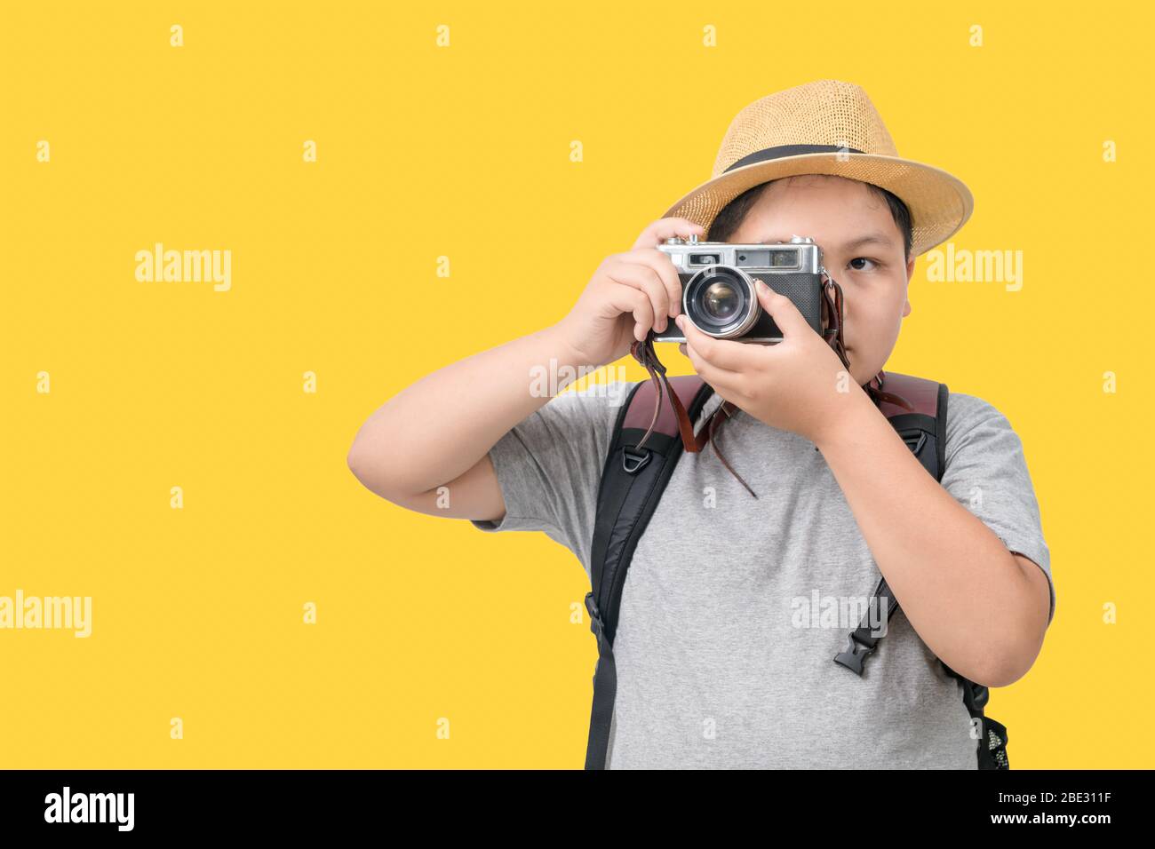 Obese boy traveler taking a picture with a vintage camera looking ...