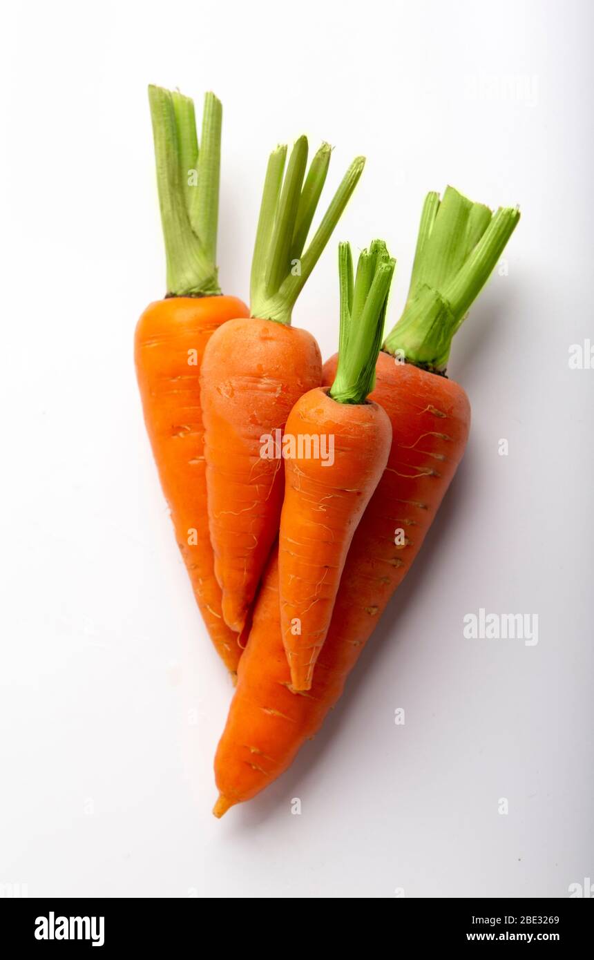 Four raw fresh carrots on white background Stock Photo - Alamy