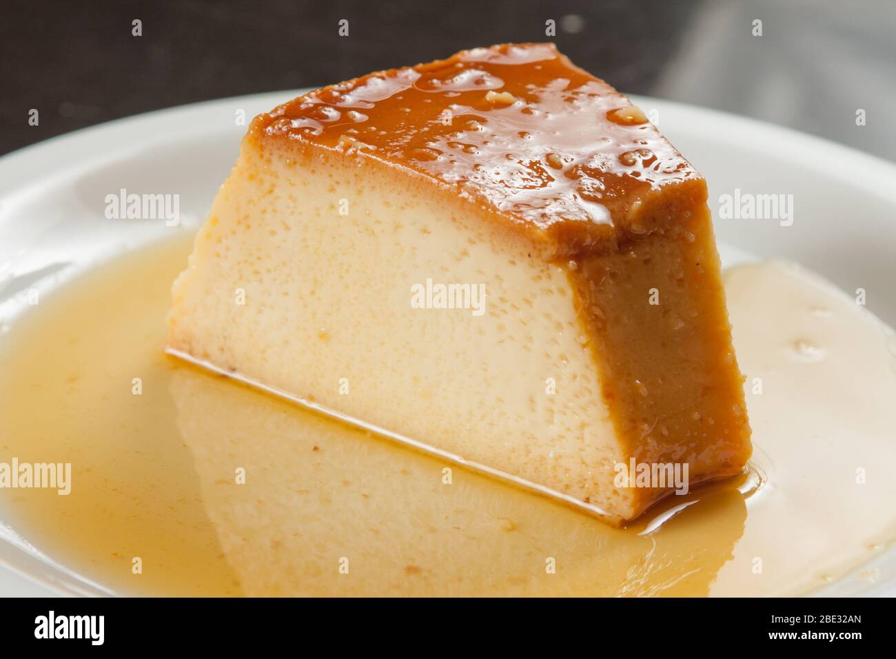 Slice of Milk Pudding over a wooden table Stock Photo - Alamy