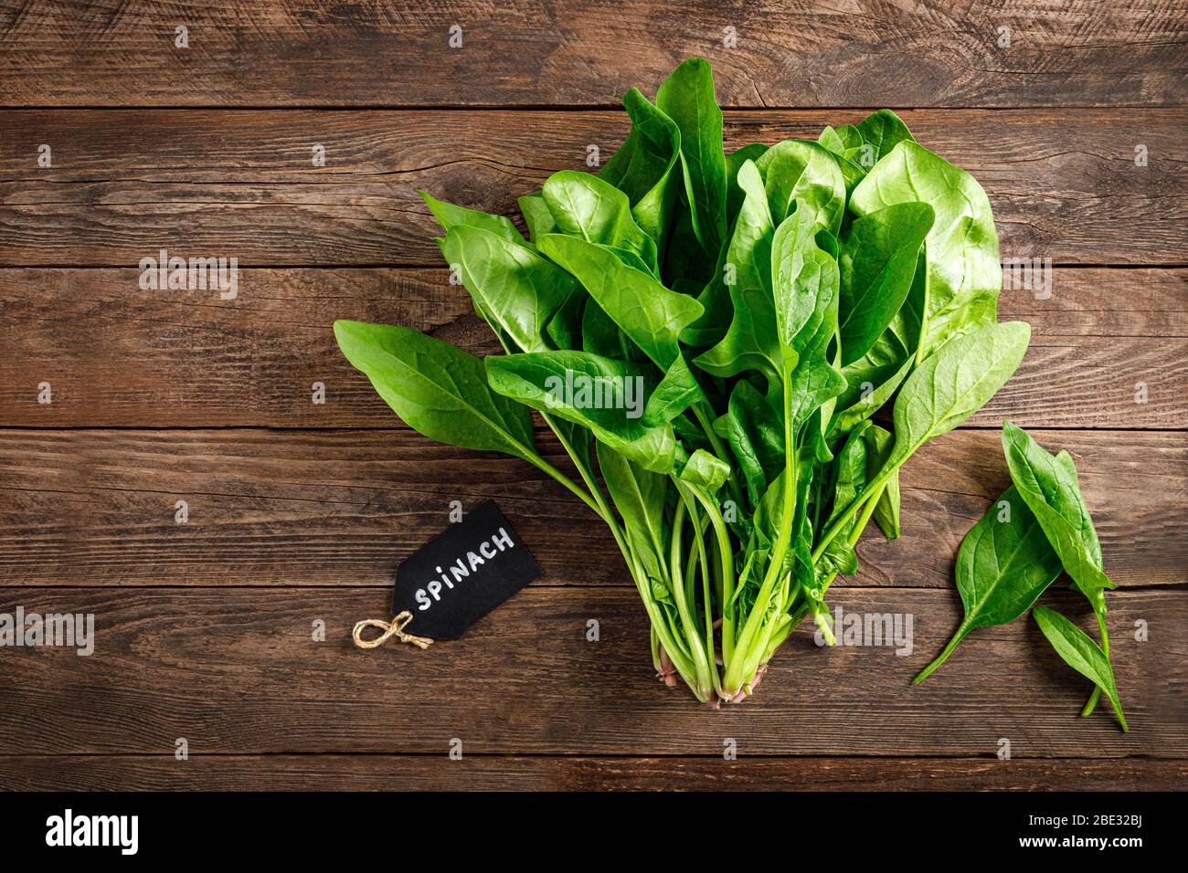 Fresh bundle of spinach on rustic wooden background Stock Photo - Alamy