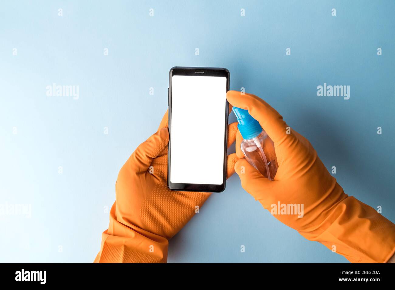 Hands wearing protective rubber gloves spraying alcohol, disinfectant ...