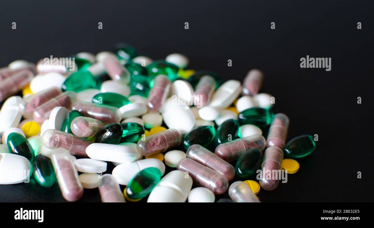 Lots of different medicine drugs, pills, tablets, capsules on black ...