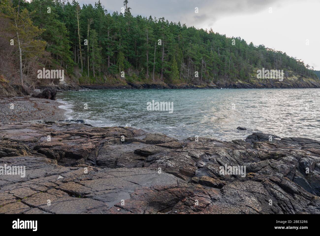 Landscape of horizontal rock formations, forested hill and the Pacific ...