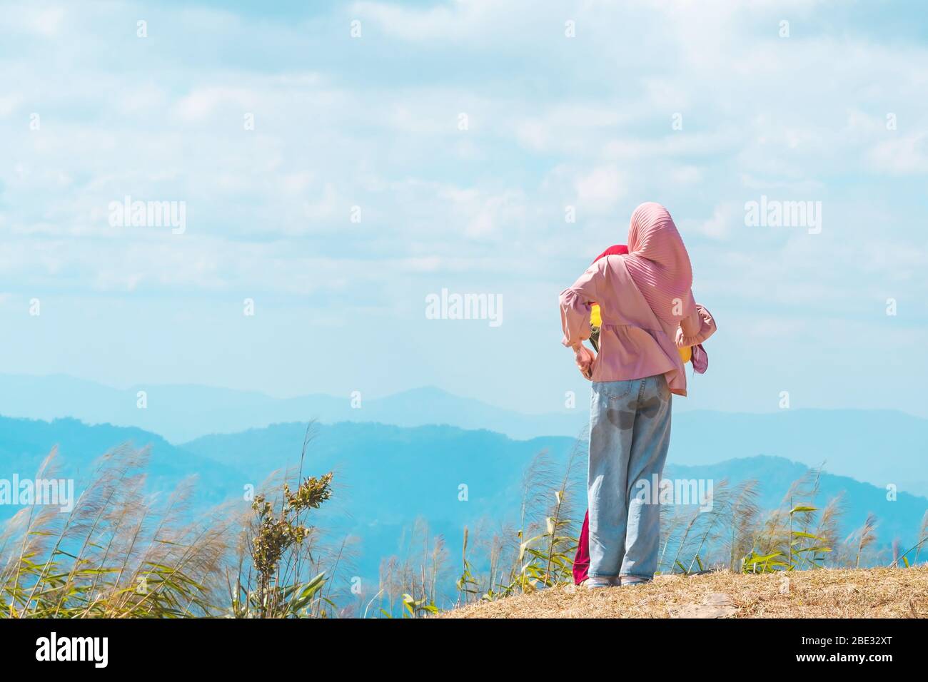 Back view of Muslim women wearing a Muslim dress and hijab enjoy on the ...