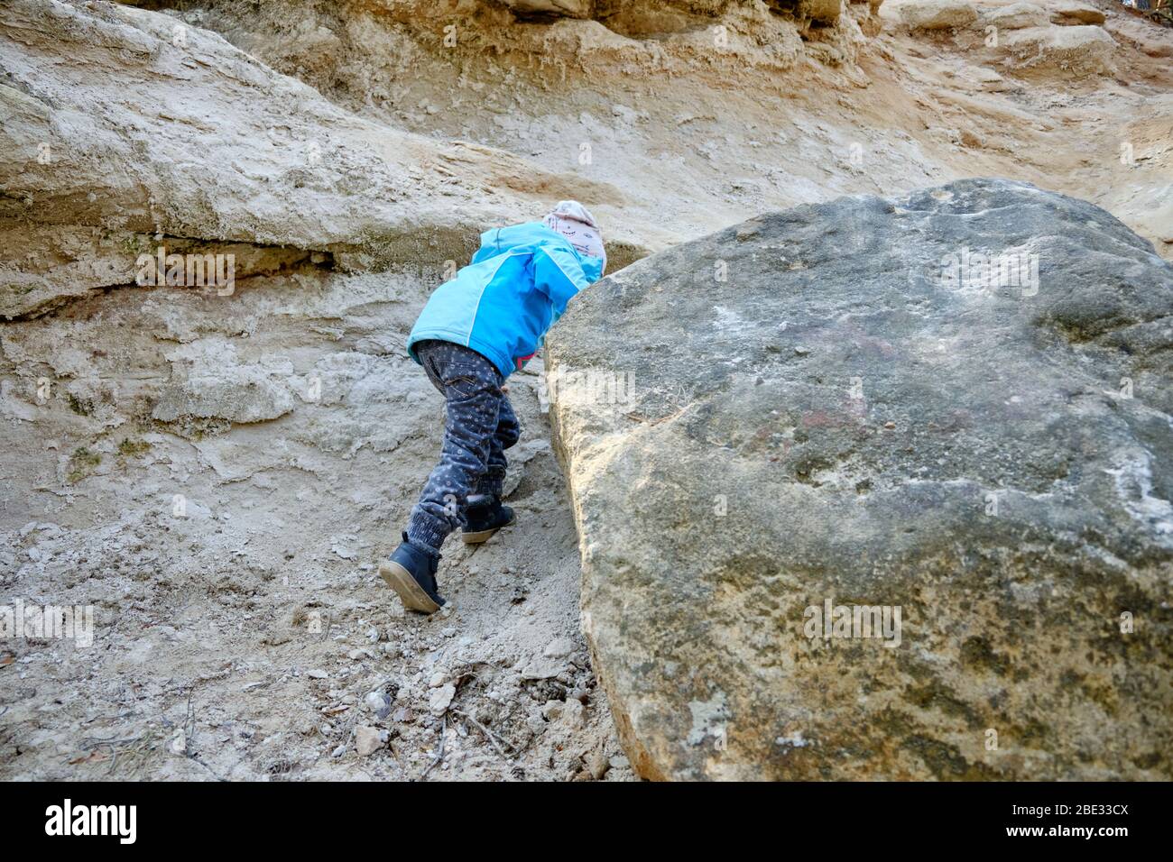 Rear view of 4 year old caucasian child girl in full length climbing up ...