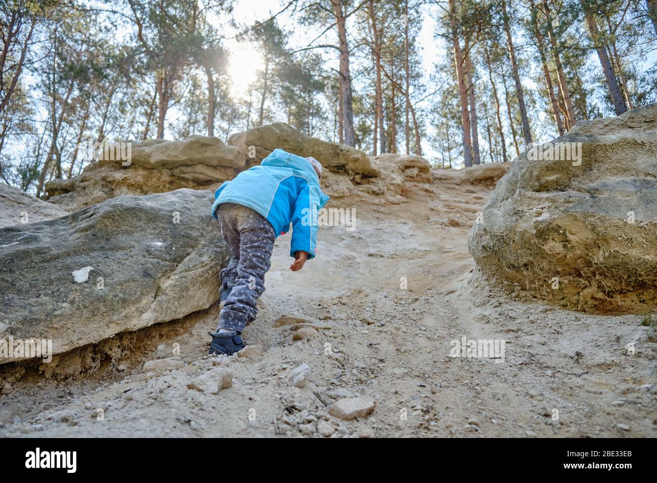 Rear view of 4 year old caucasian child girl in full length climbing up ...