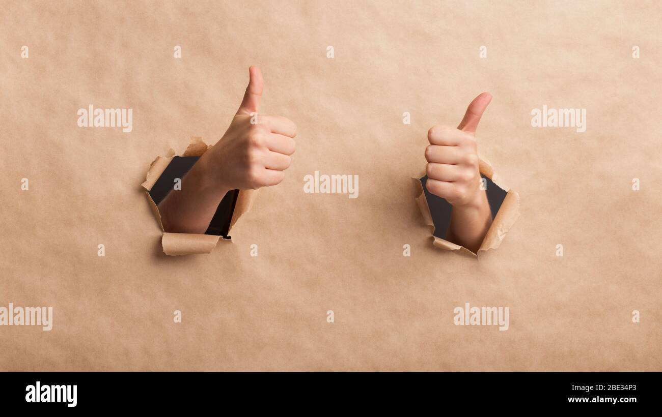 Hands showing thumbs up over cardboard wall, safety delivery Stock ...