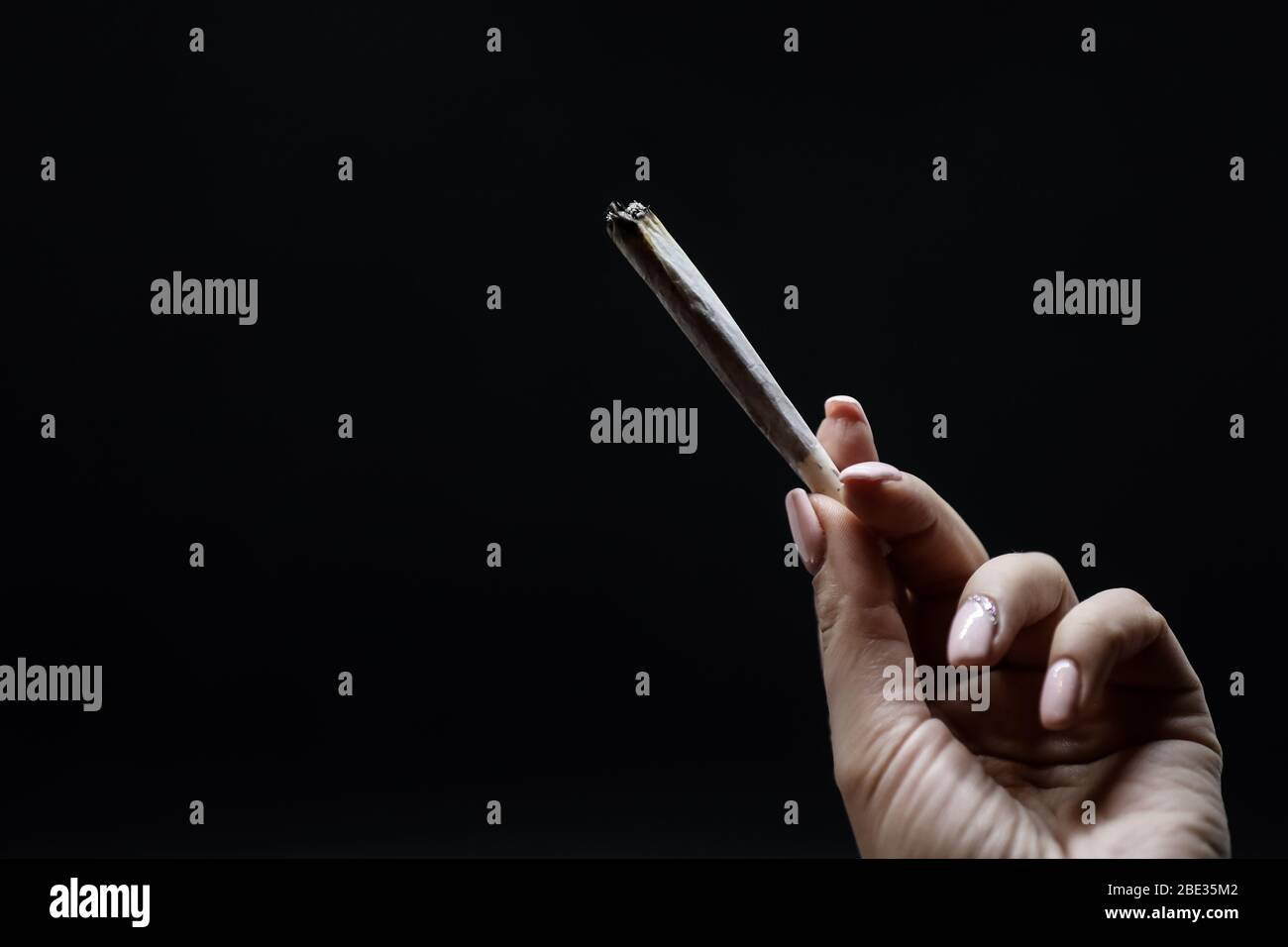 Woman hand holding cigarette. Smoking cannabis joint. Medical use ...