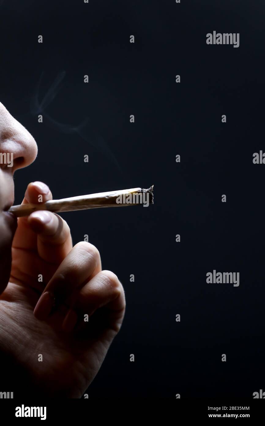 Woman hand holding cigarette. Smoking cannabis joint. Medical use ...