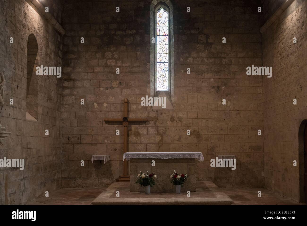 Decorated stained glass window and altar in the small church in the ...