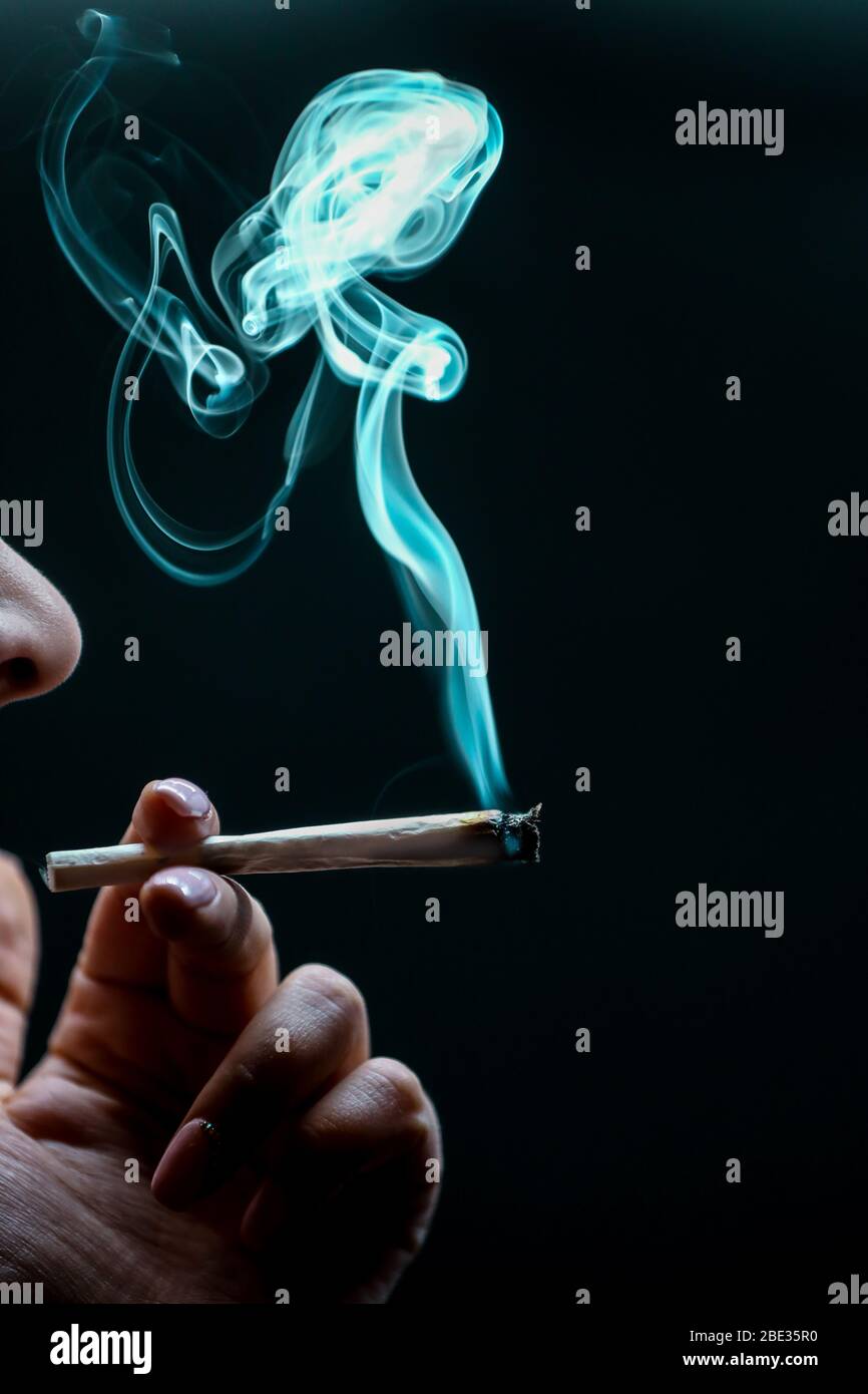 Woman hand holding cigarette. Smoking cannabis joint. Medical use ...