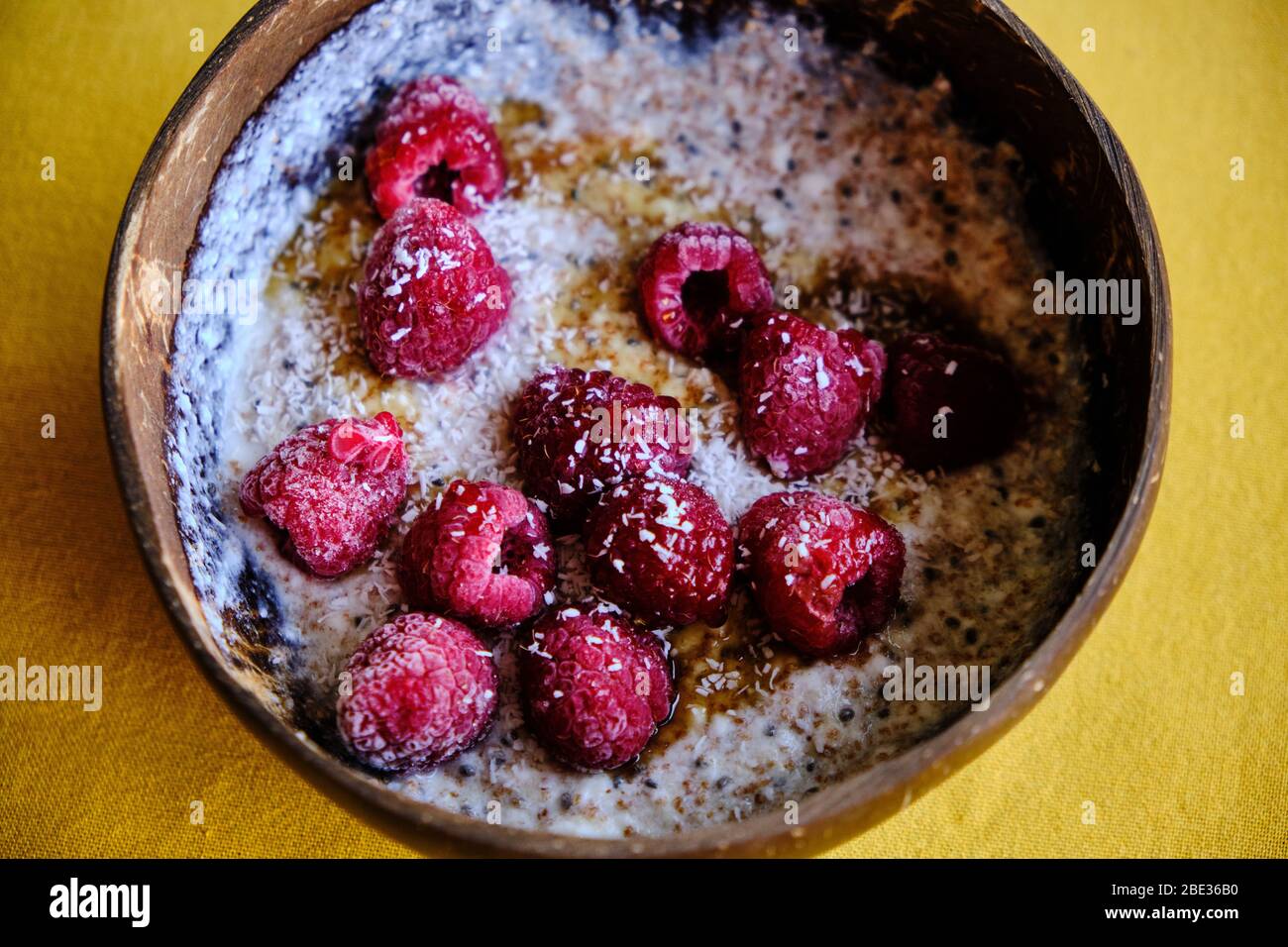 yoghurt with teff and quinoa topped with raspberry, coconut flakes and ...