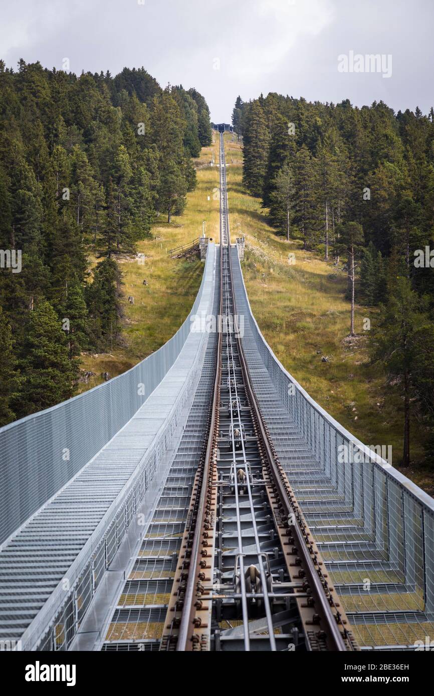 The rail track of the Resciesa funicular railway extends over a metal ...