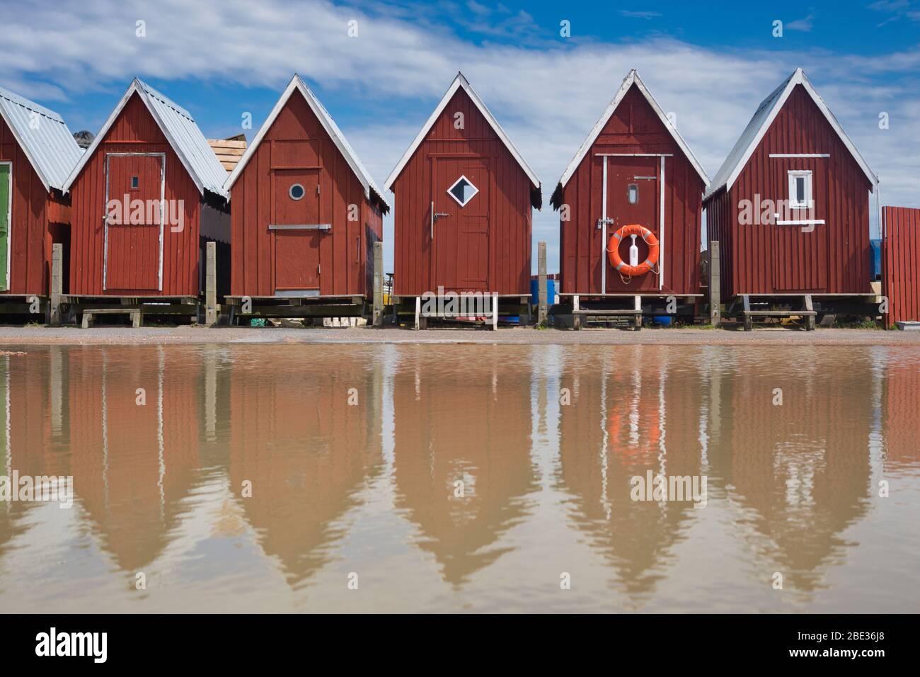 coastal huts in water reflection with lifebuoy attached Stock Photo - Alamy