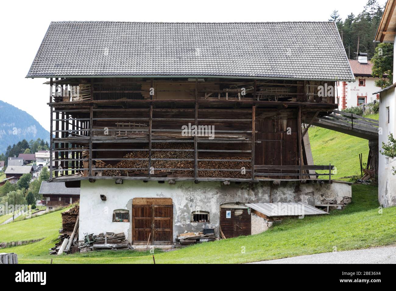 Large traditional wooden and stone barn or the outskirts of Ortisei ...