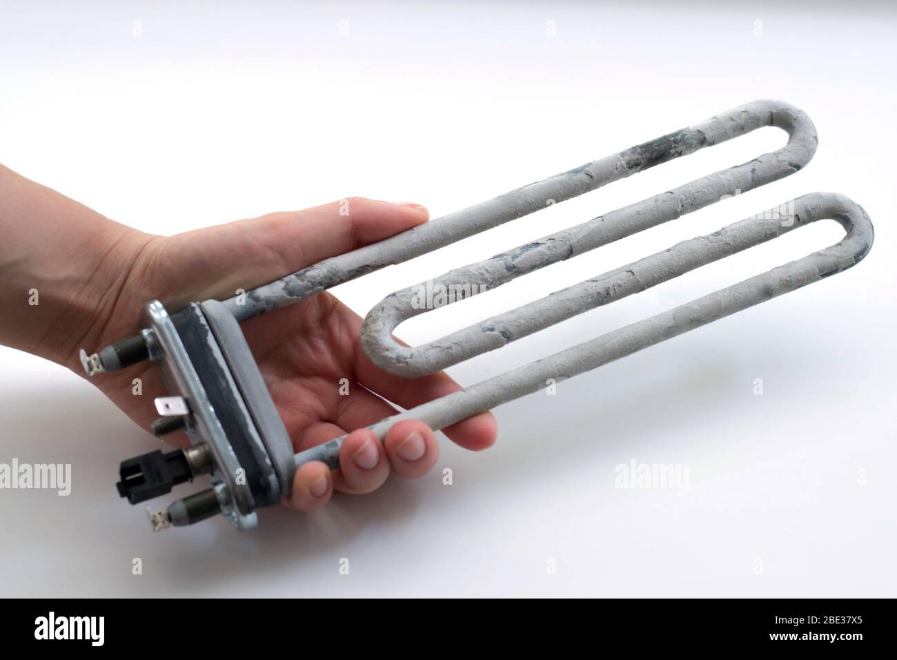 Hand holding washing machine heater on a white background Stock Photo ...