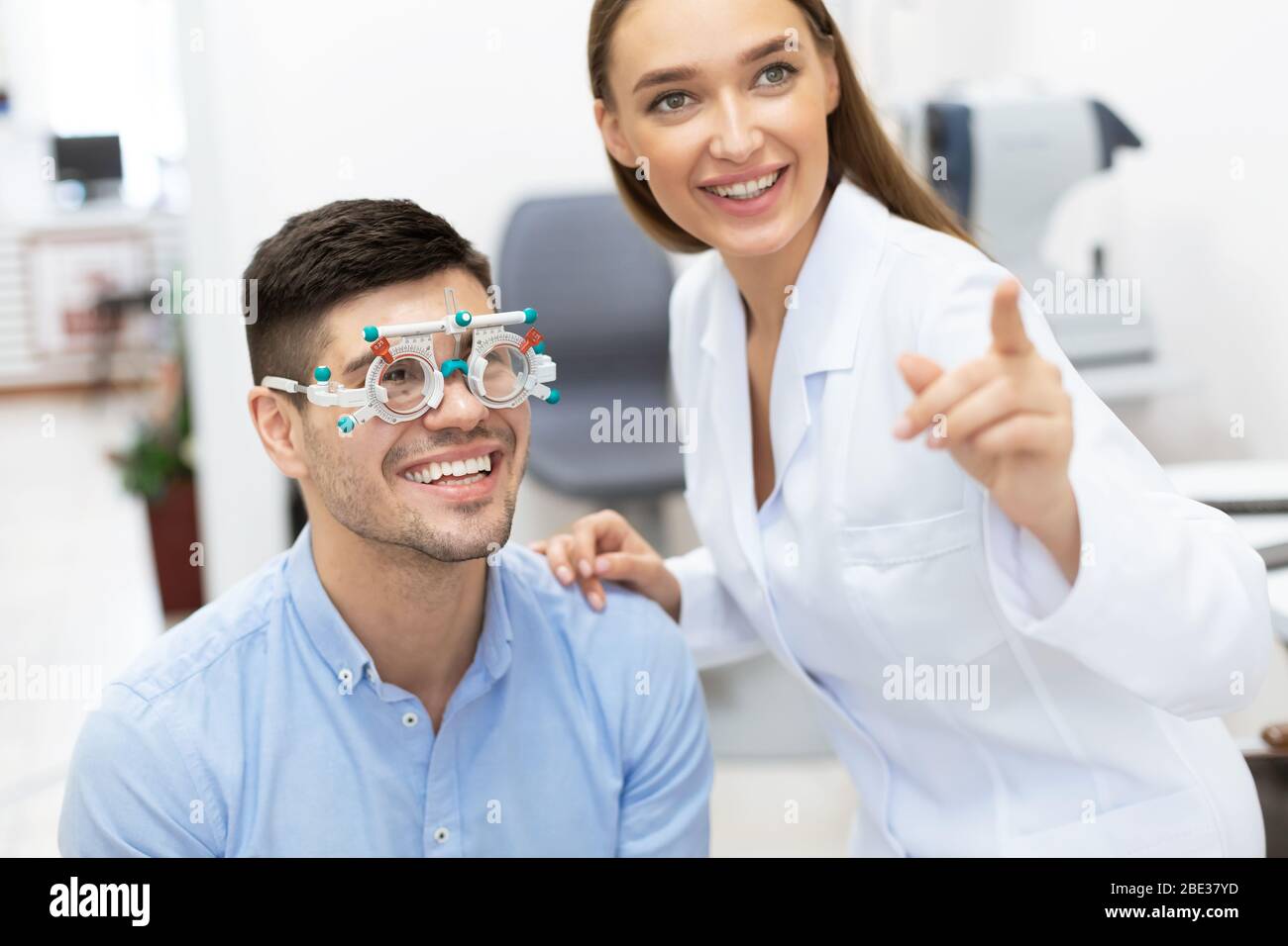 Optometrist checking patients vision with trial frame Stock Photo - Alamy