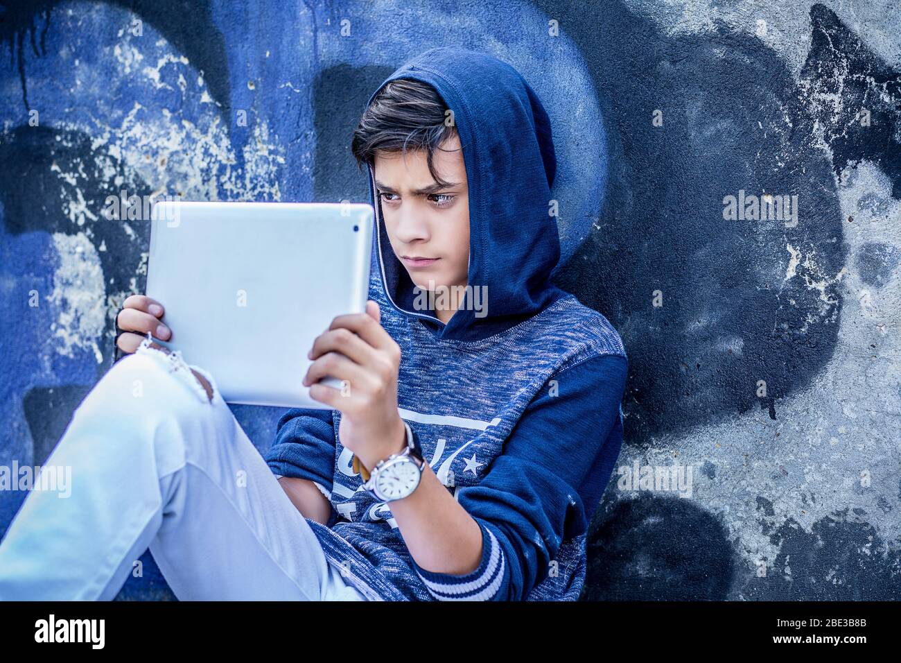 child, angry funny looking boy using, holding laptop, pad computer ...