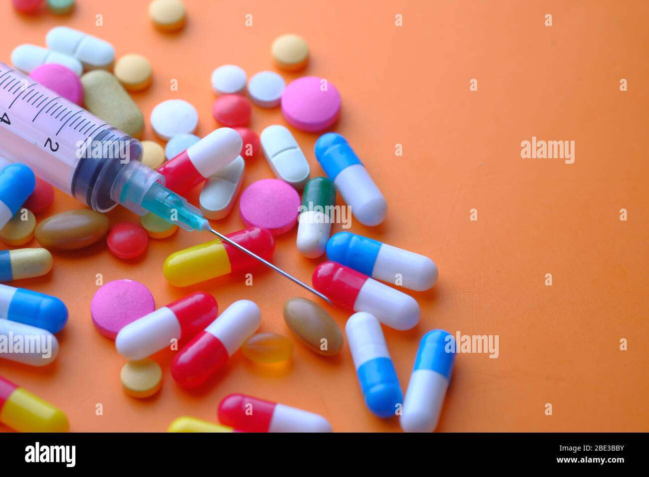 Assorted medical drugs and syringe on table Stock Photo - Alamy