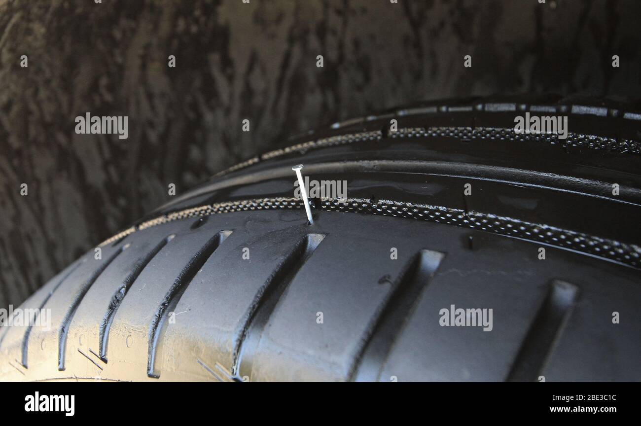 Car Tire Pierced By Metal Nail Close Up Stock Photo - Alamy