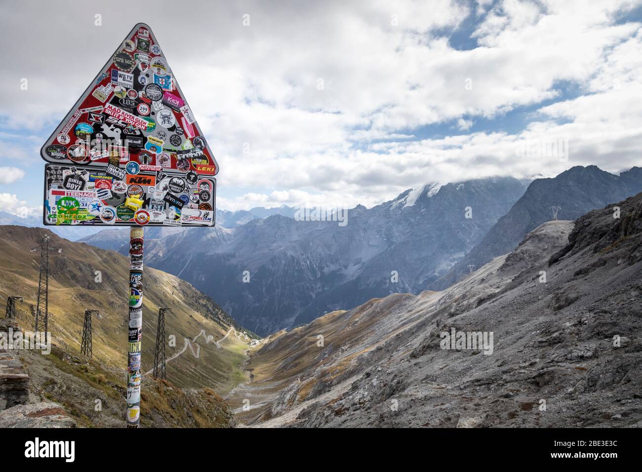 The reverse of a road sign covered in stickers at the summit of the ...